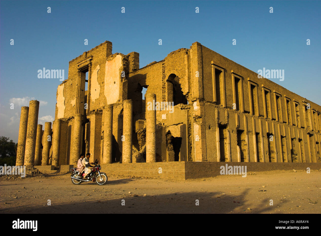 AFGHANISTAN Jalalabad Men ride motorbike past Seraj ul Emorat Light of buildings Palace and ...