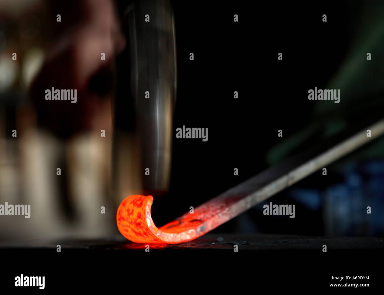 A Blacksmith bashing a piece of metal with a hammer Stock Photo - Alamy