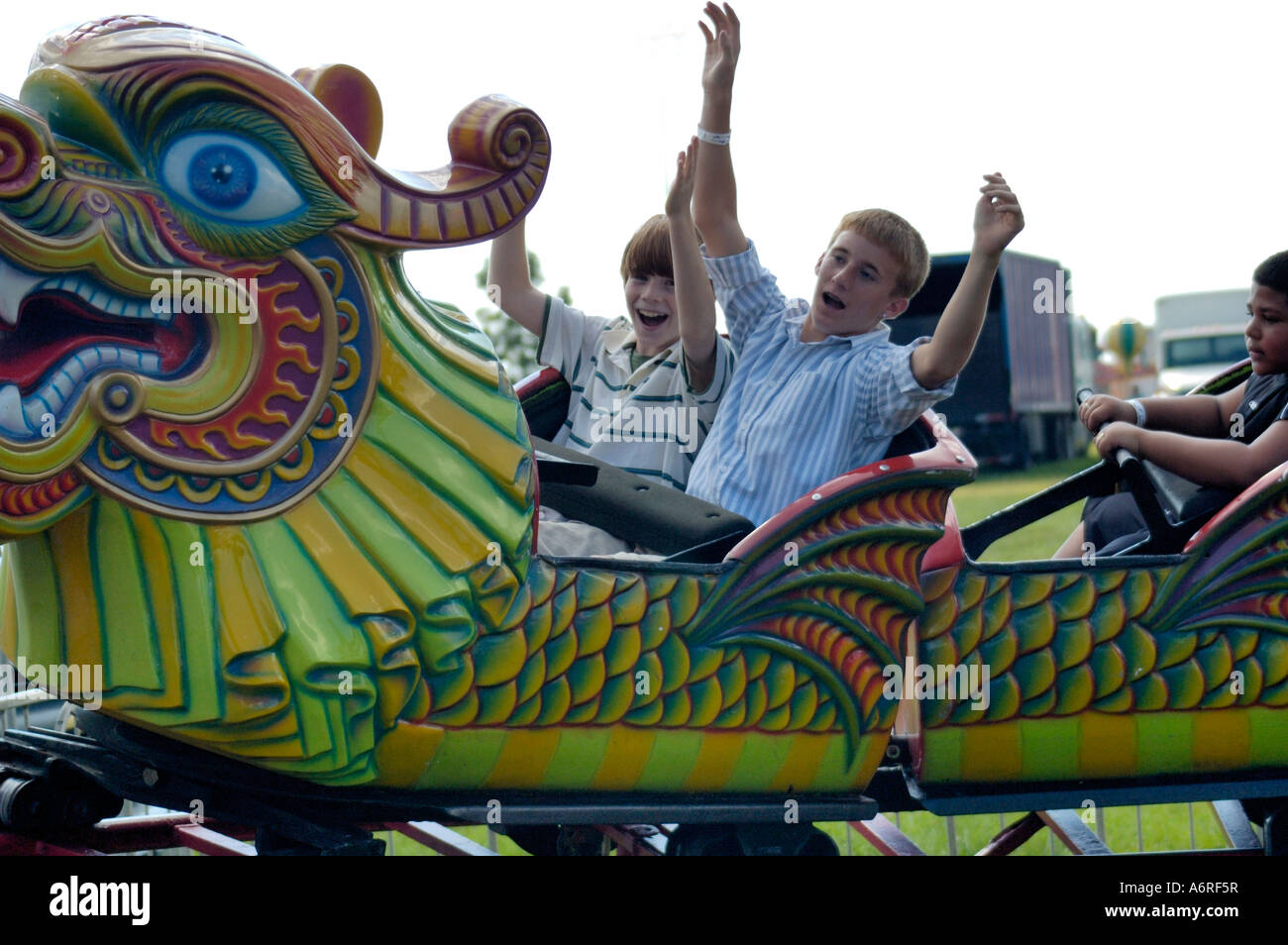Teenage boys having fun on a oriental dragon roller coaster ride at the ...