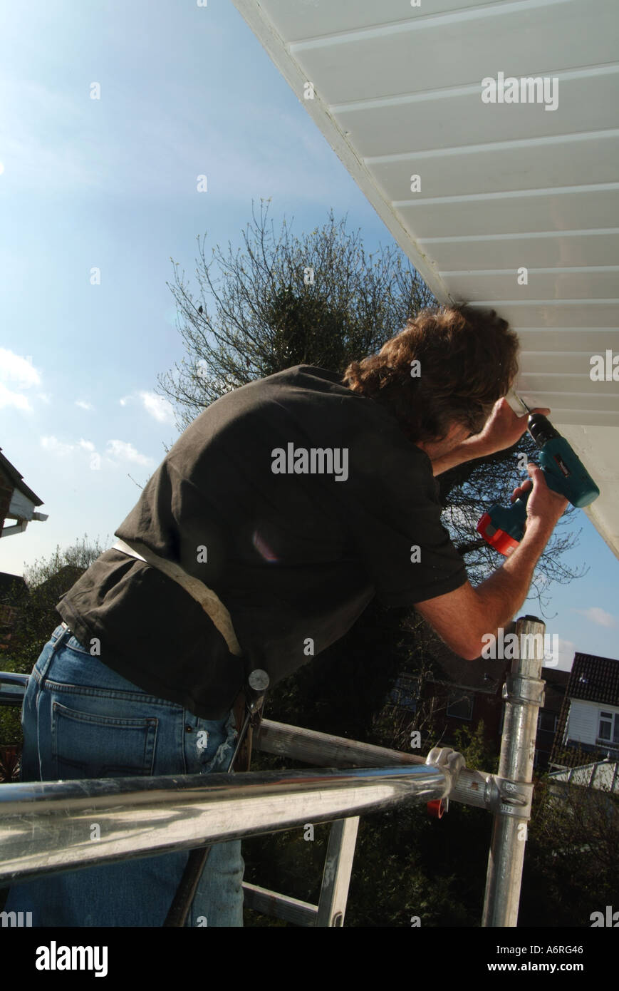 Carpenter working from scaffold tower at domestic residence to over ...