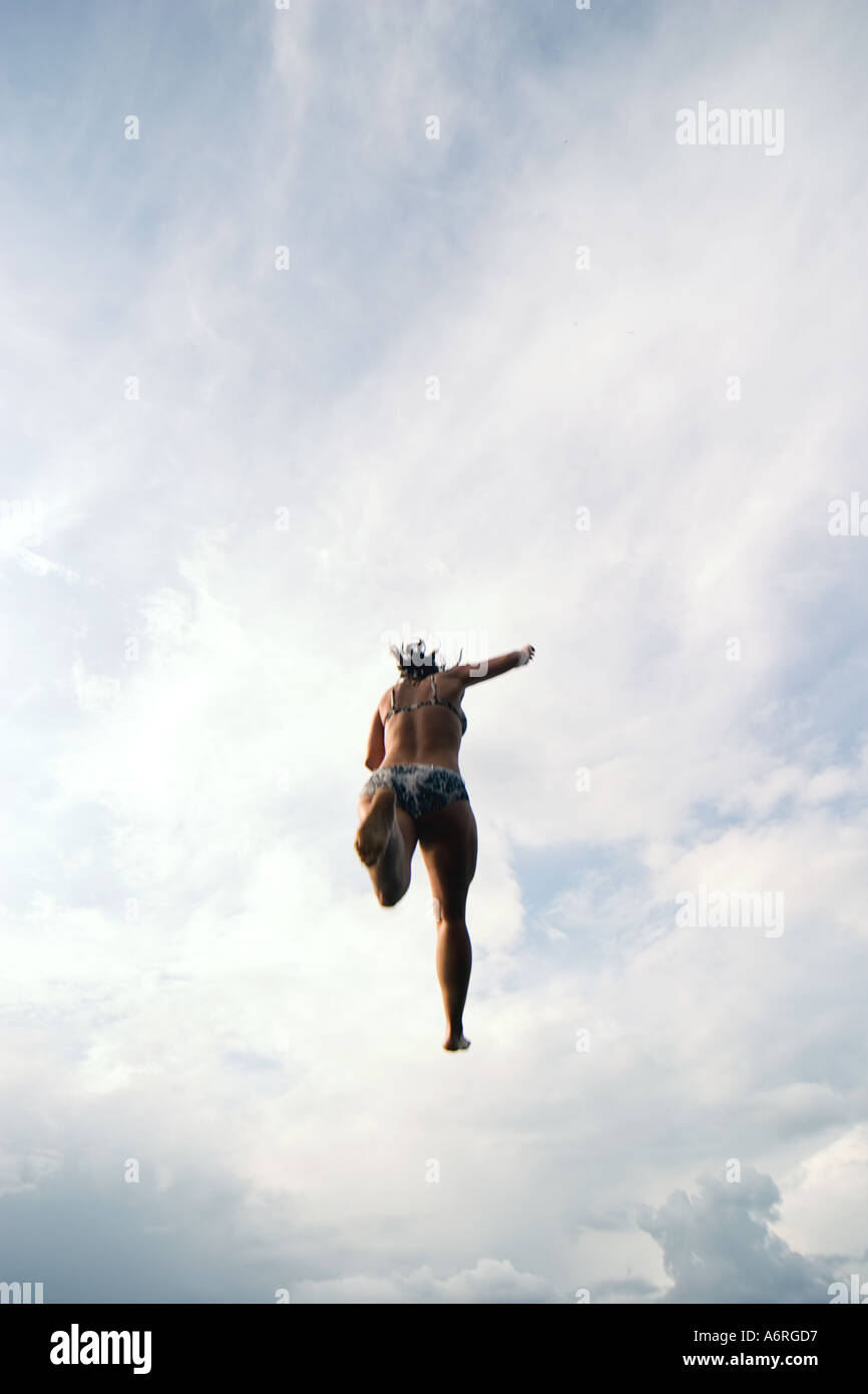 young woman jumps from a cliff Stock Photo - Alamy