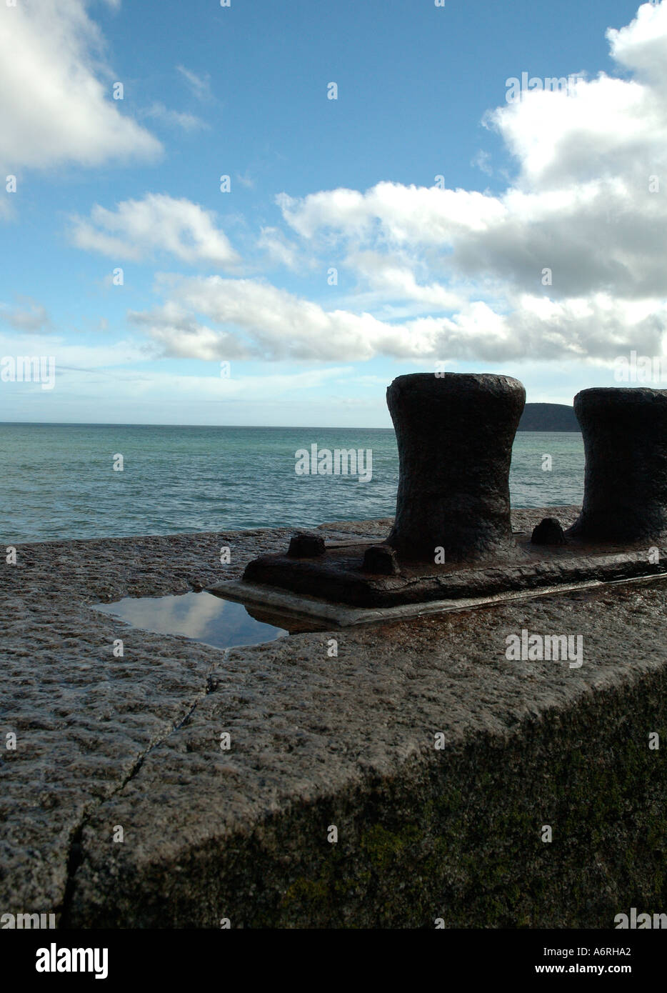 Old mooring bollards against blue sky in Cornish harbour Stock Photo ...