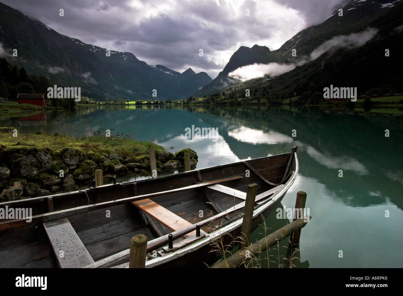 A Norwegian rowing boat lies safely tethered in the turquoise water of ...