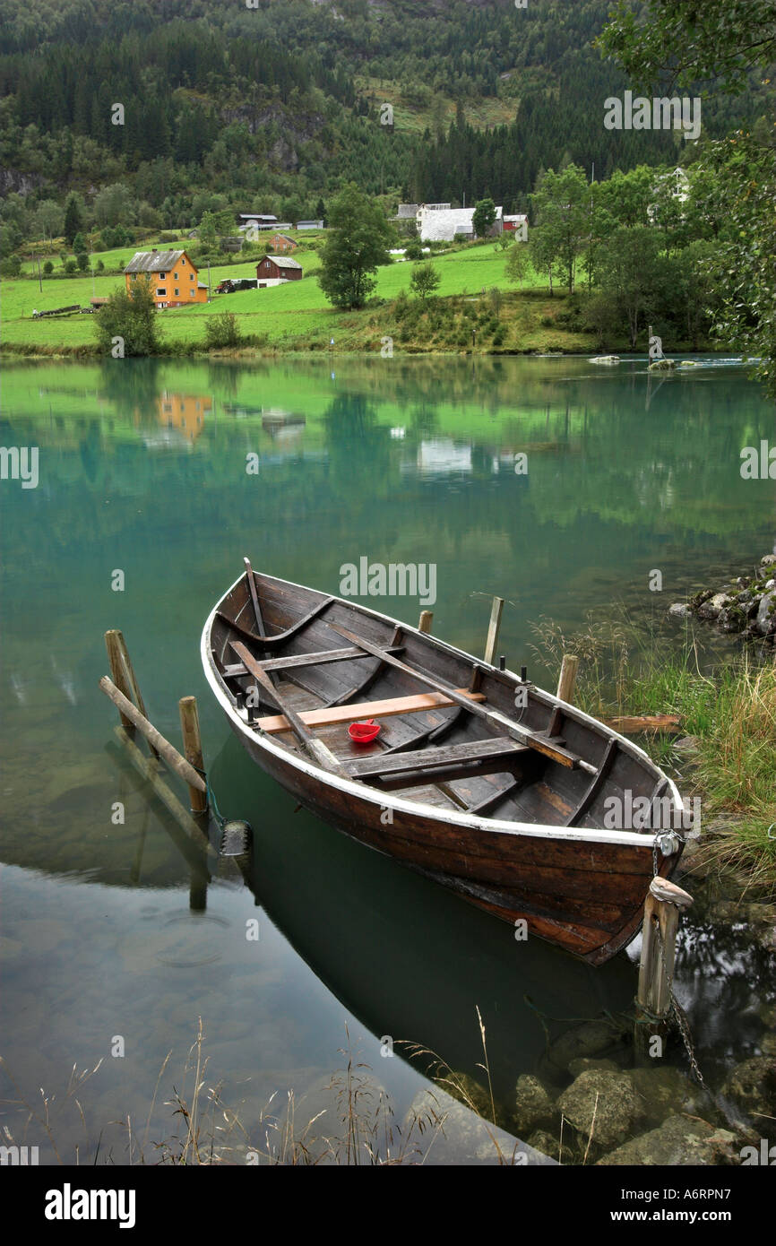 A Norwegian rowing boat lies tethered in the mirror like turquoise ...