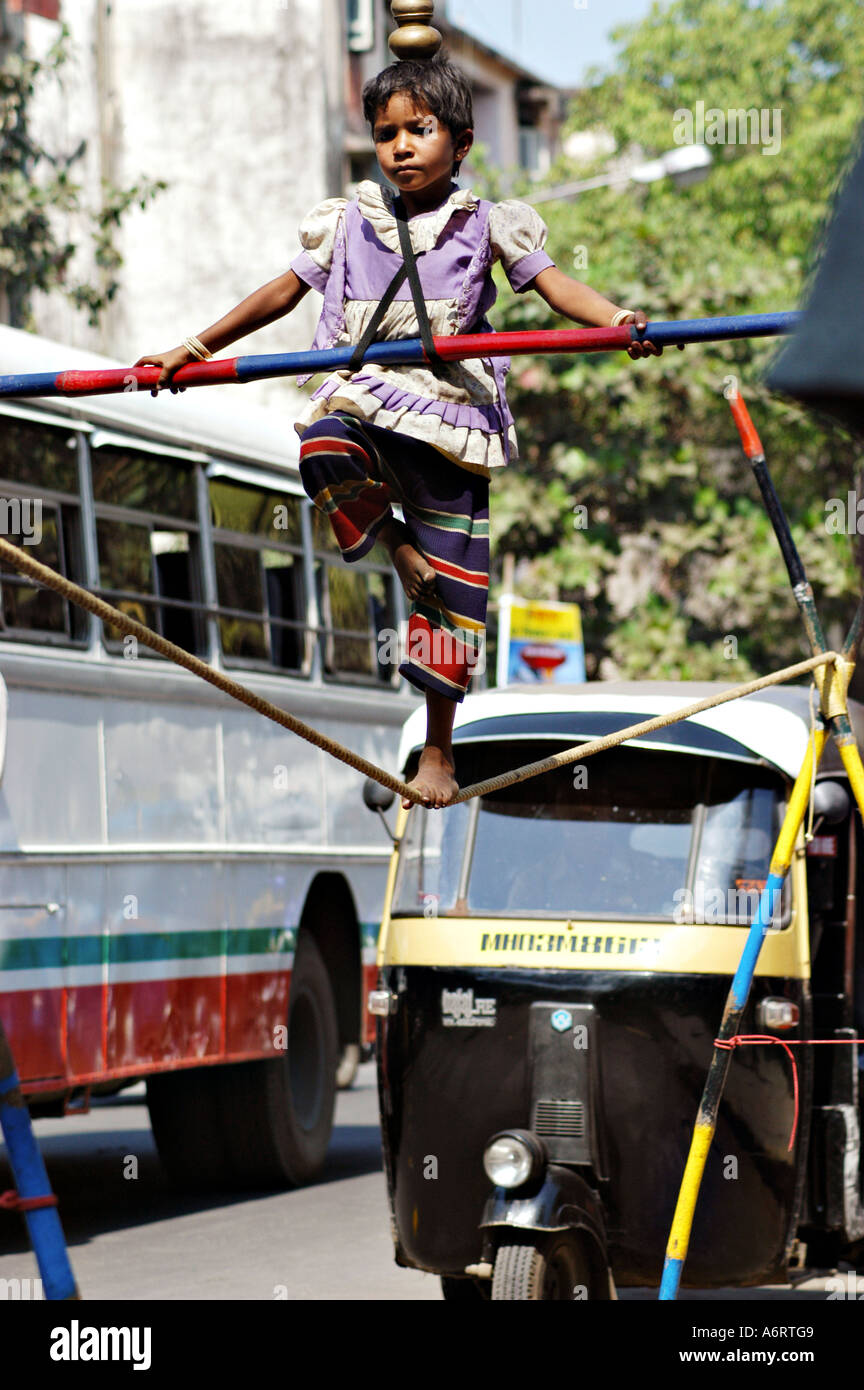Asian girl working street performer balancing act by walking on rope ...