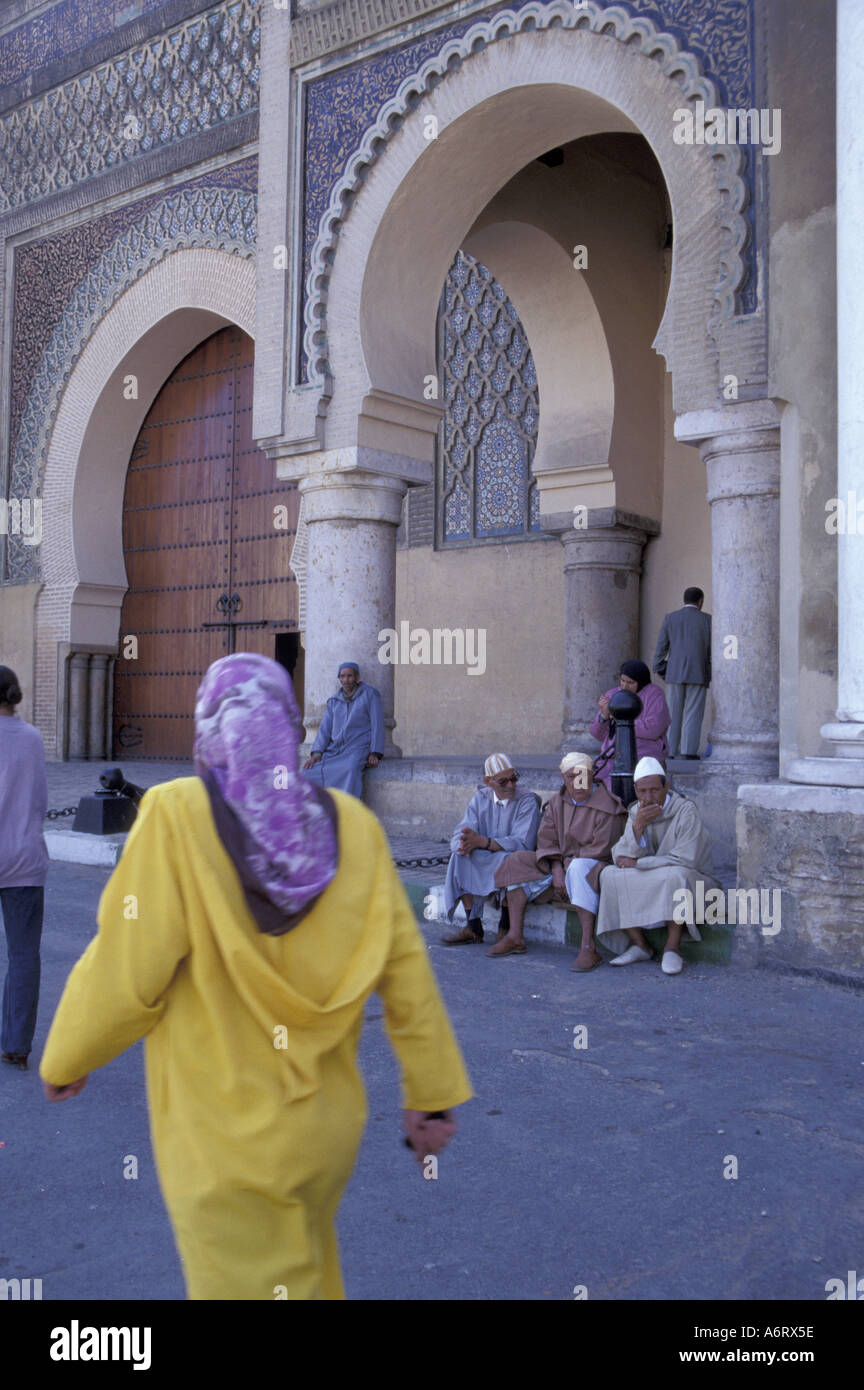 Africa, Morocco, Meknes Traditionally dressed Muslim woman walks by old ...