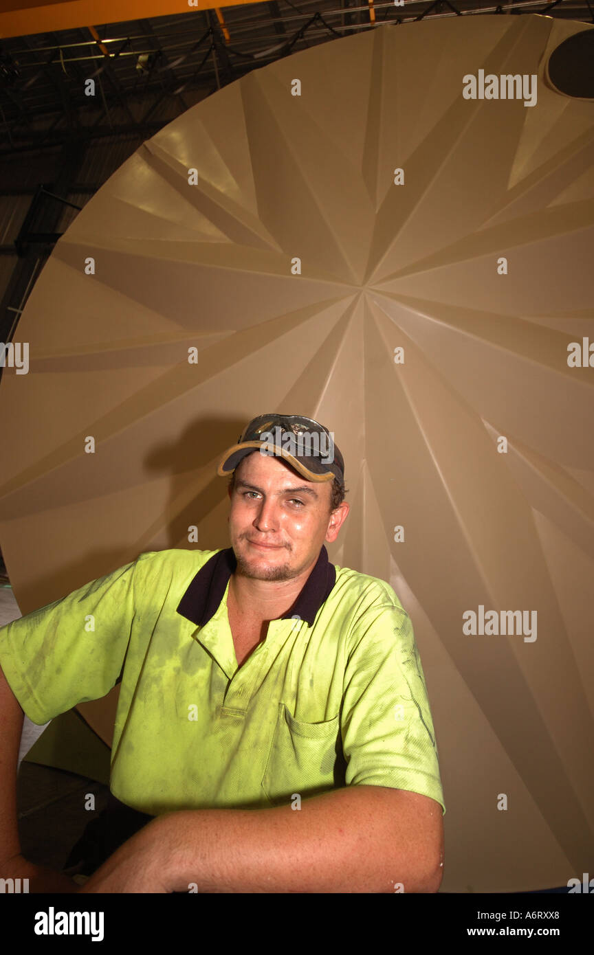 worker posing in front of plastic rain water tank Stock Photo - Alamy
