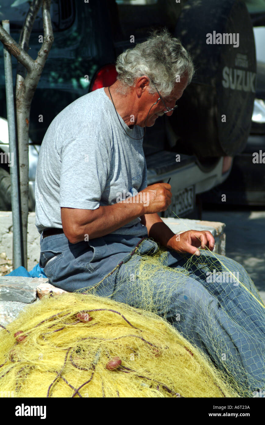 Fisherman mending nets Stock Photo - Alamy