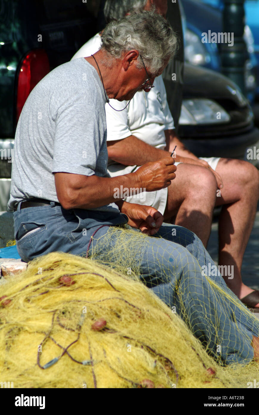 Fisherman mending nets Stock Photo - Alamy