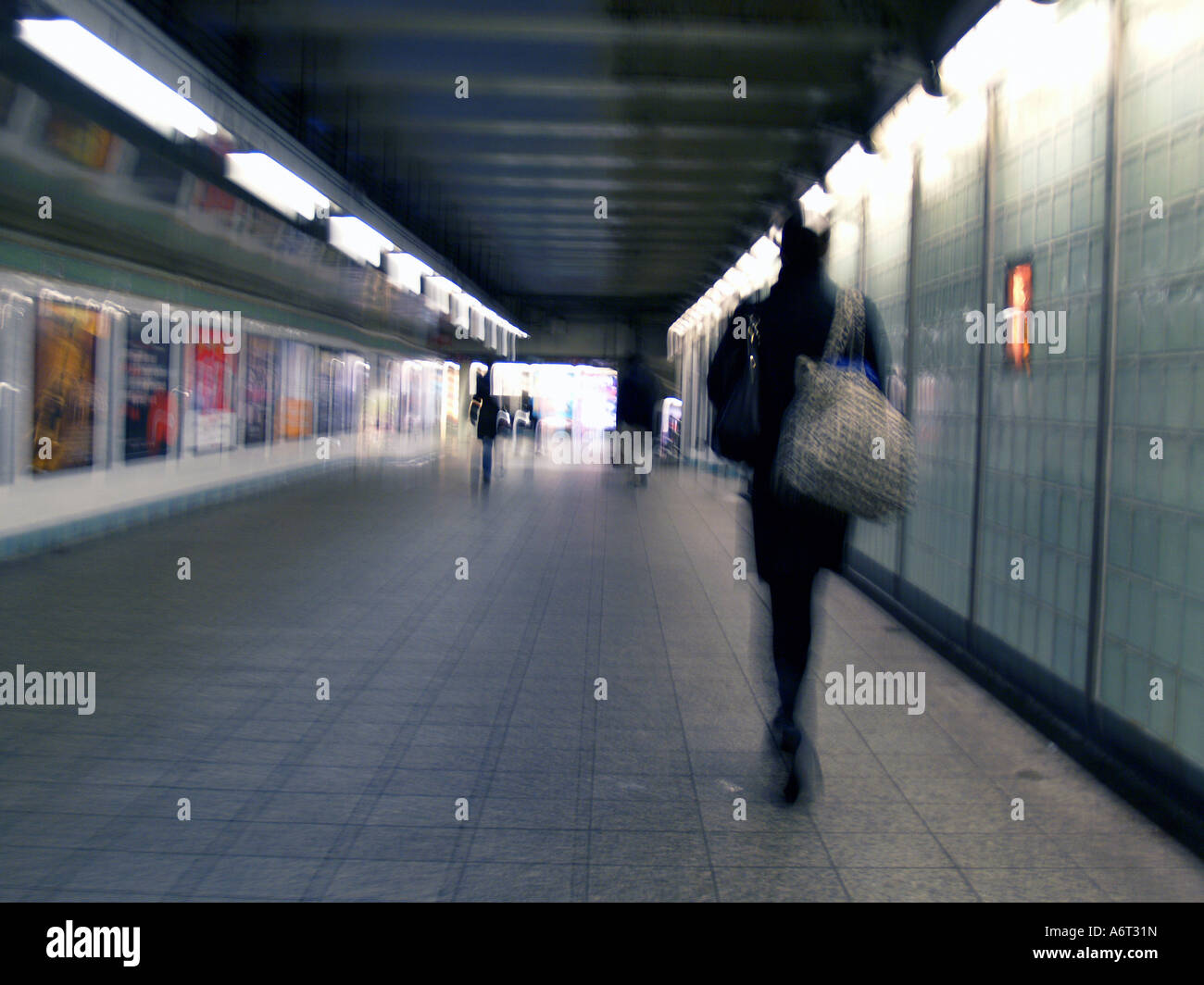 Female commuter walking through the illuminated Times Square subway ...