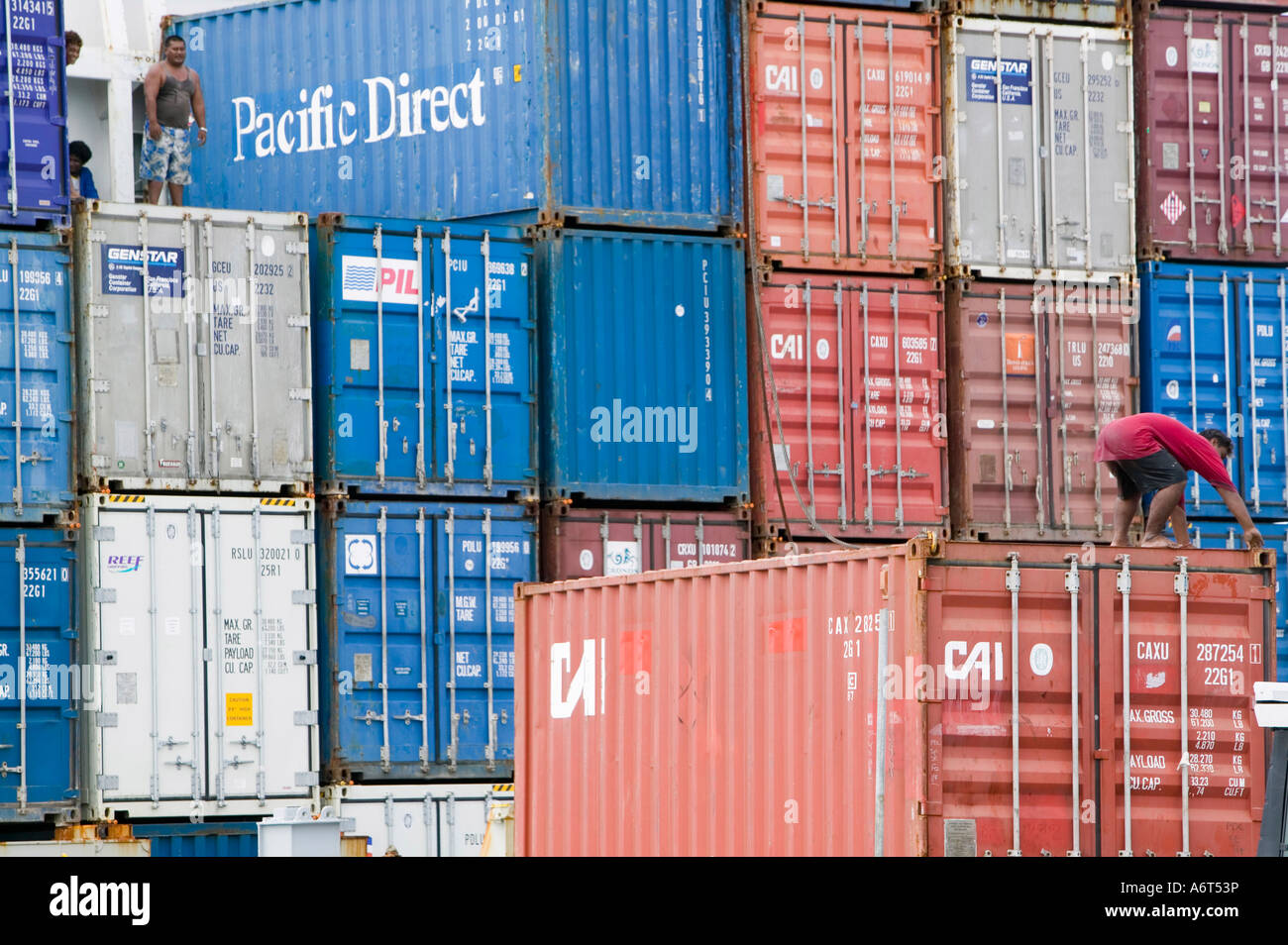 Tuvaluan workers loading containers onto a supply ship on Funafuti ...