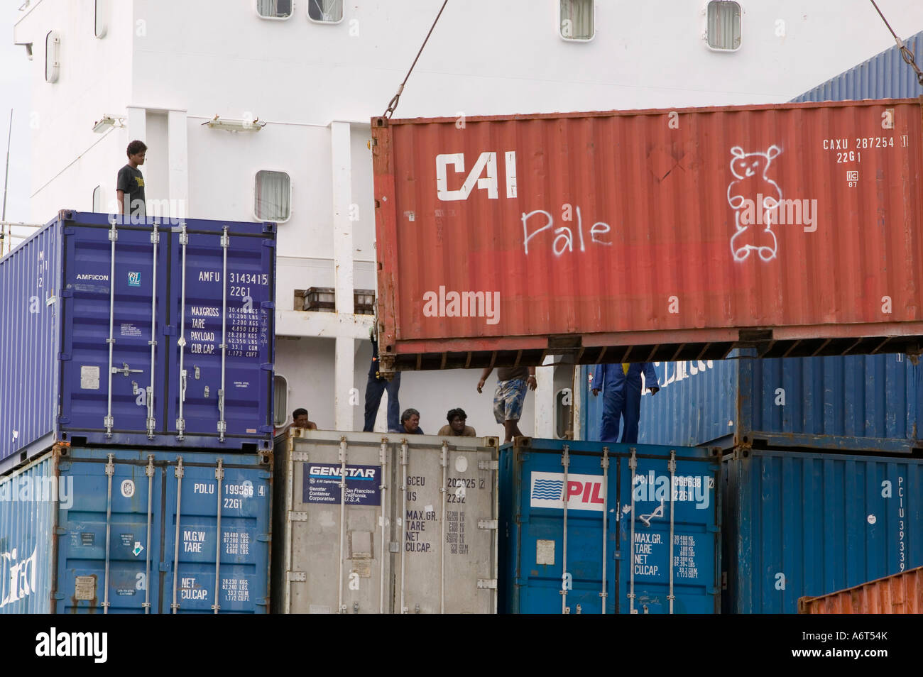 Tuvaluan workers loading containers onto a supply ship on Funafuti ...