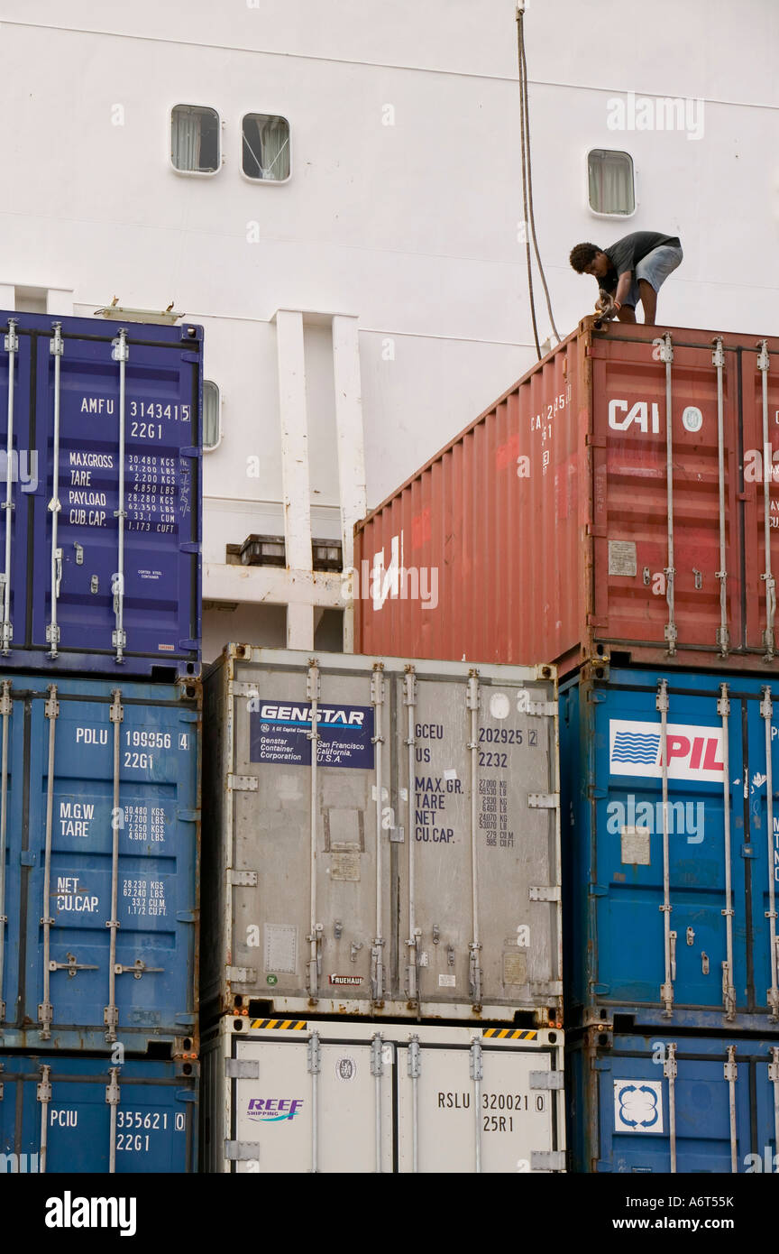 Tuvaluan workers loading containers onto a supply ship on Funafuti ...