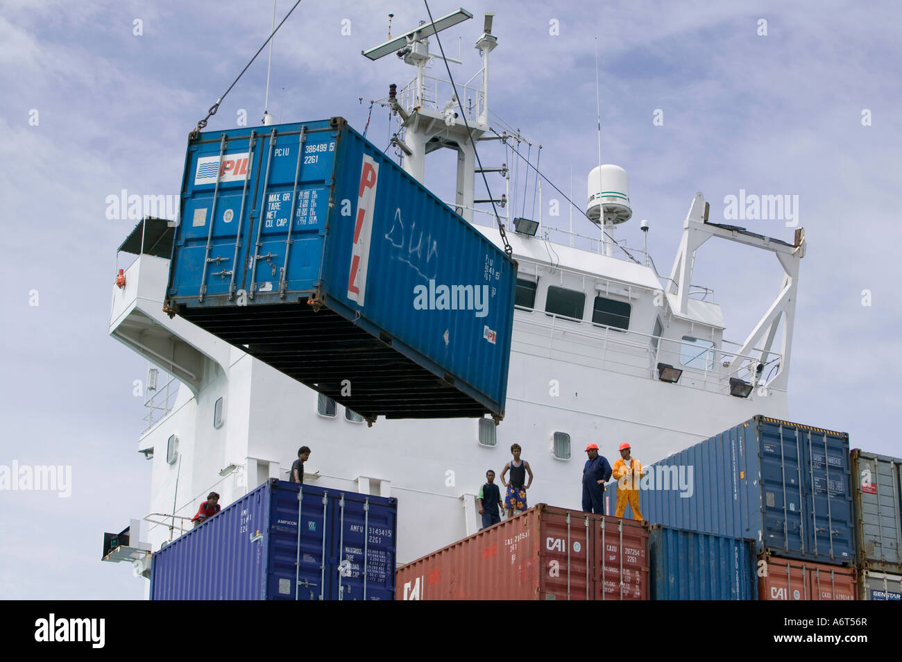 Tuvaluan workers loading containers onto the supply ship on Funafuti ...