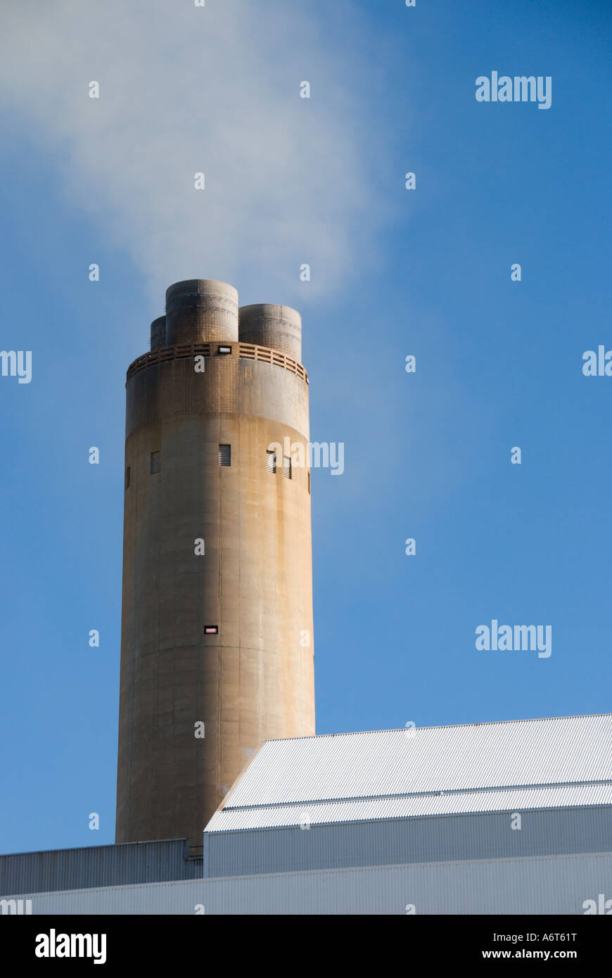 A power station chimney Stack with smoke on a plain blue sky. Aberthaw ...