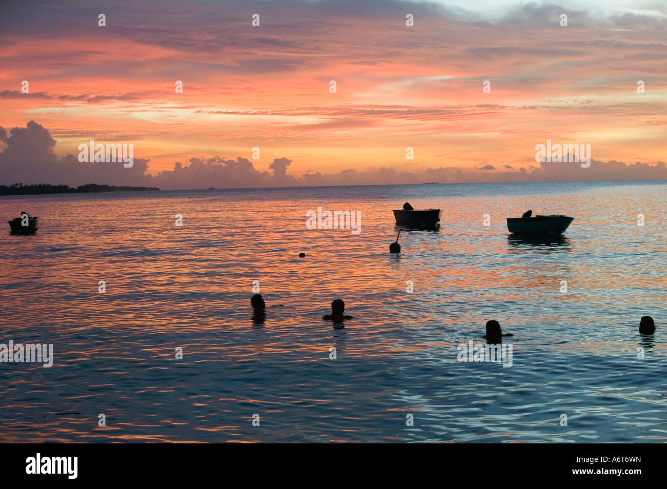 Tuvaluans sat in the sea at sunset on Funafuti island Stock Photo - Alamy