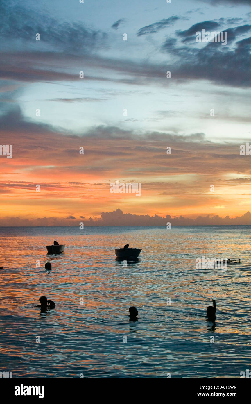 Tuvaluans sat in the sea at sunset on Funafuti island Stock Photo - Alamy