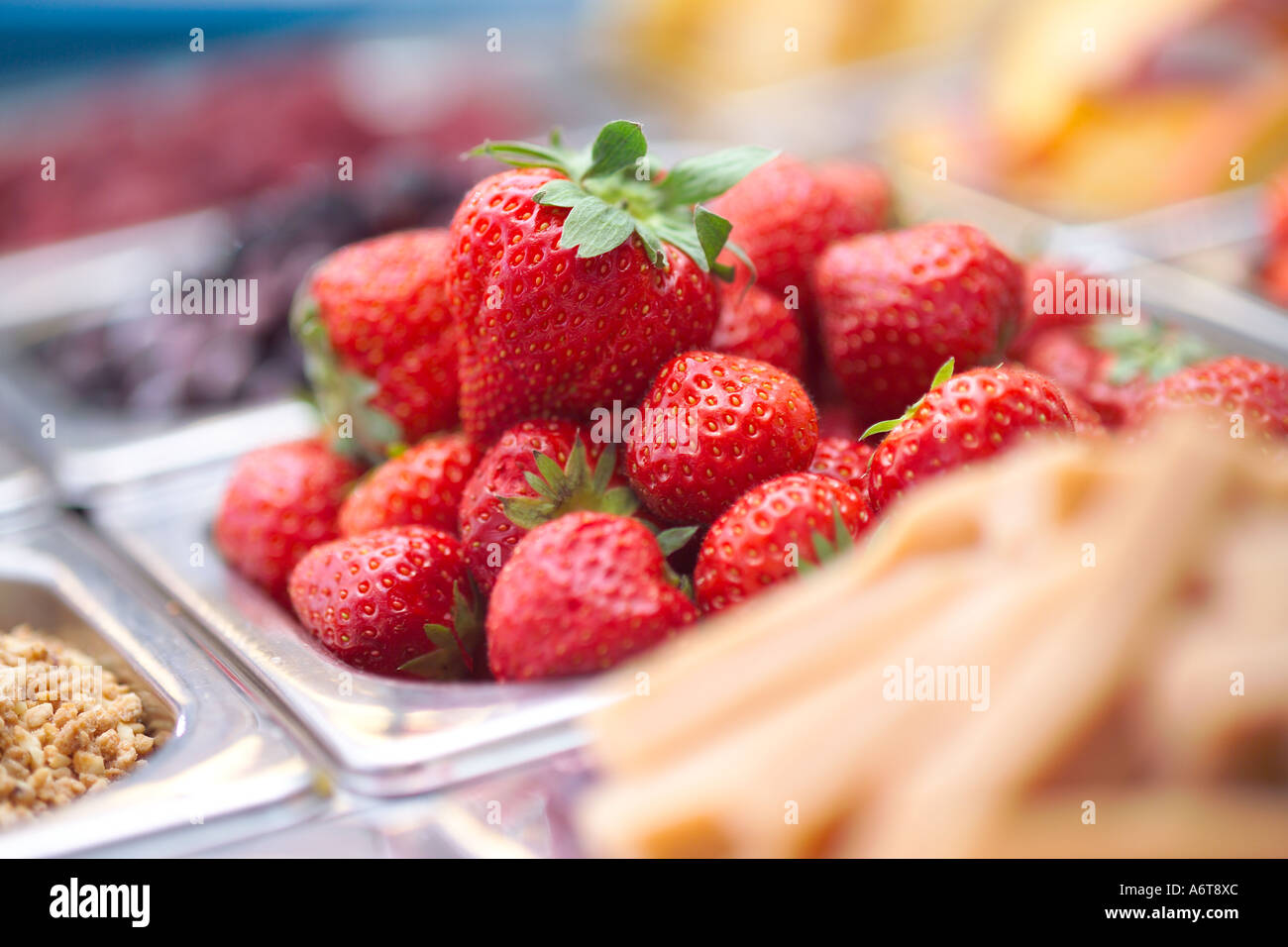 Strawberries and other toppings in a display case in an ice cream ...