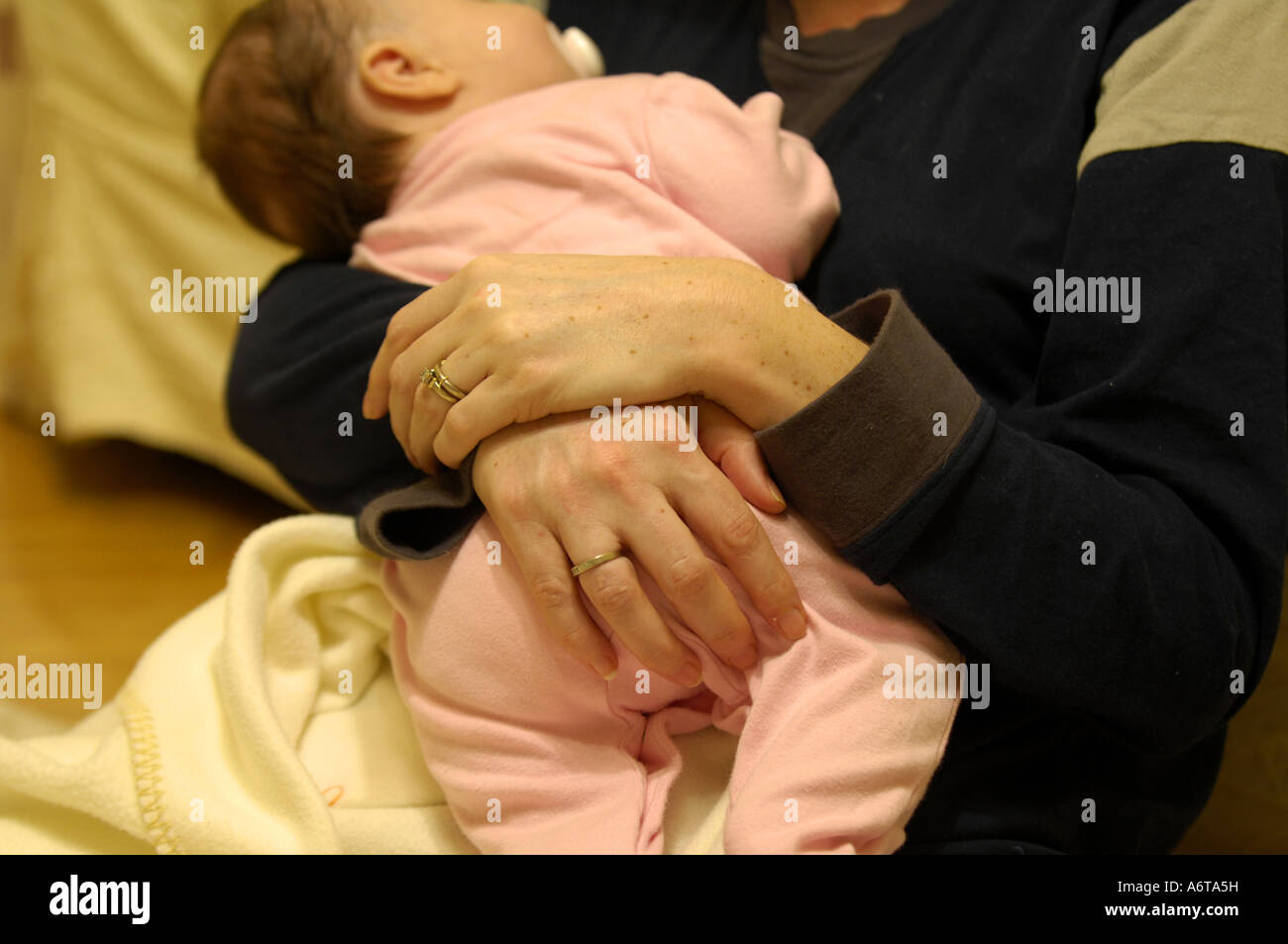 mother holding sleeping sleepy baby hands female woman horizontal ...