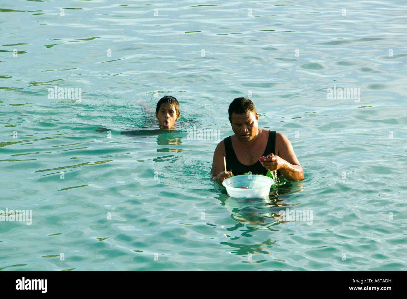 a tuvaluan man sat in the sea eating raw fish Stock Photo - Alamy