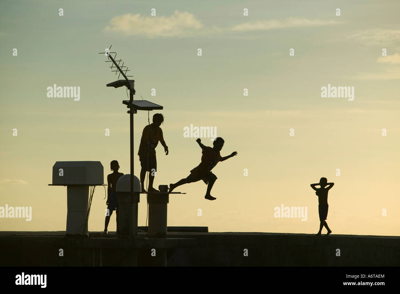 Children playing on the wharf at sunset, Funafuti, Tuvalu Stock Photo ...