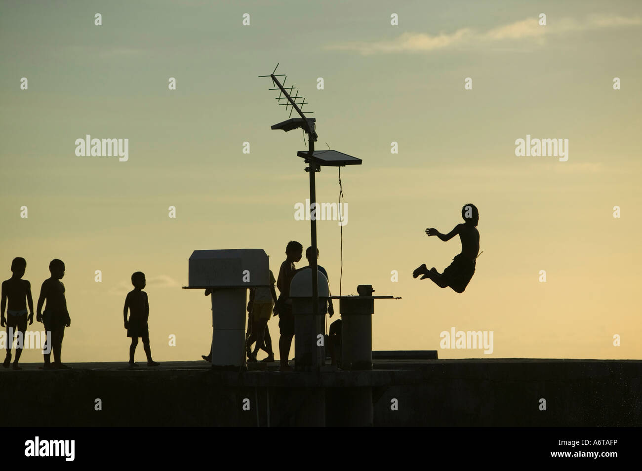 Children playing on the wharf at sunset, Funafuti, Tuvalu Stock Photo ...