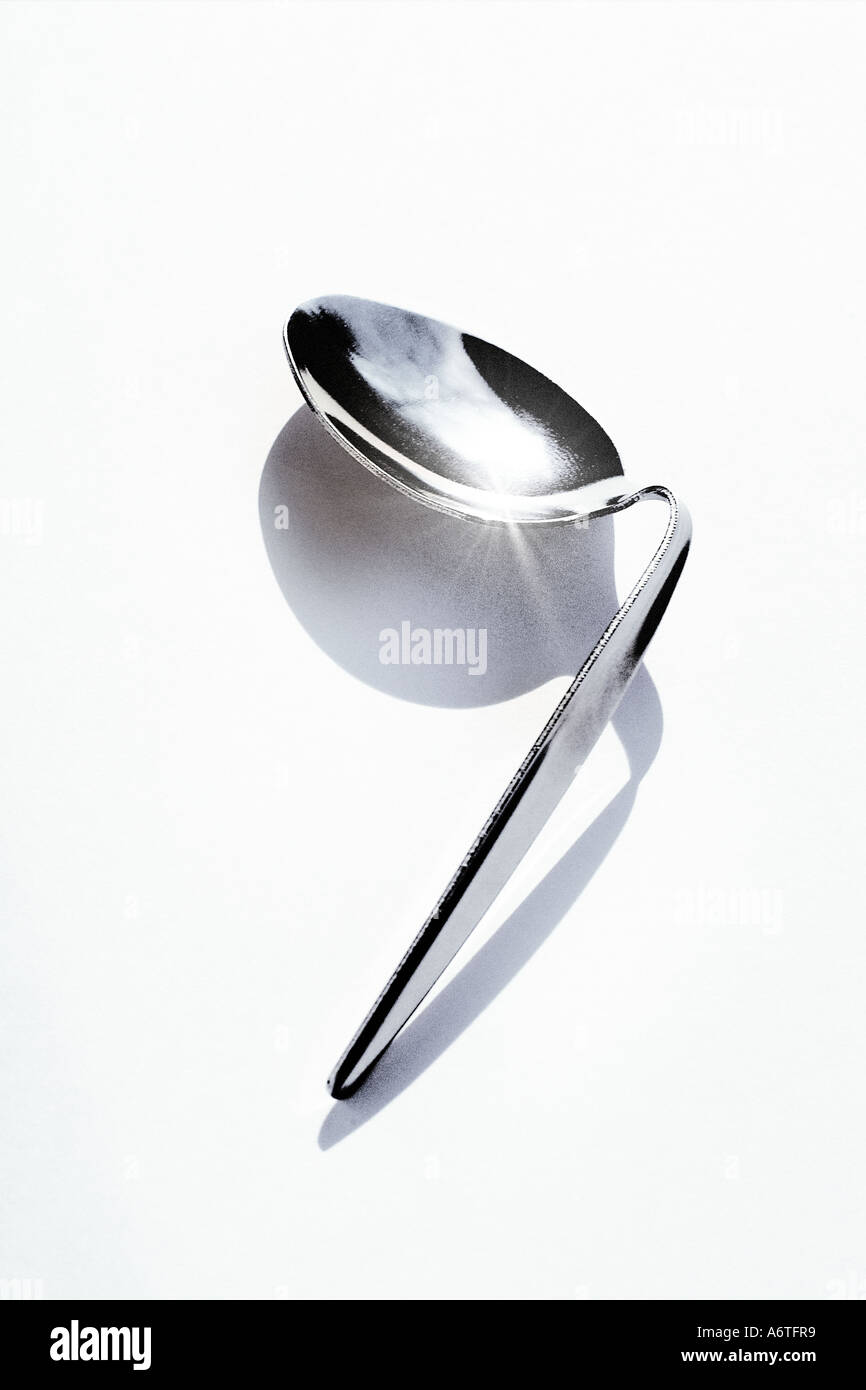 A bent shiny metal spoon Stock Photo - Alamy