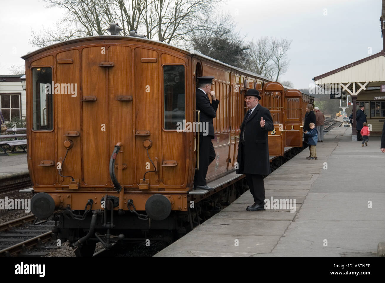 Railway staff talking by an elegant preserved wooden coach built by the ...