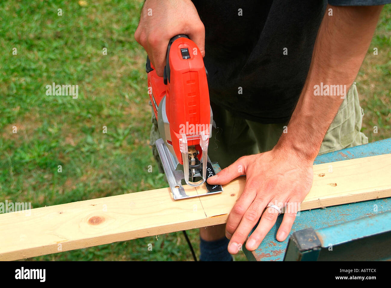 Man sawing wood with a jig saw Stock Photo - Alamy