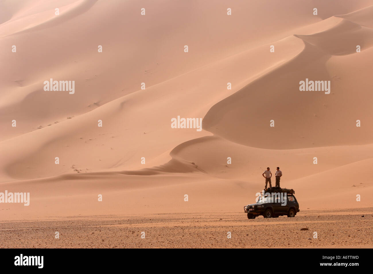 Two men admiring the desert view from the top of a 4WD vehicle Stock ...
