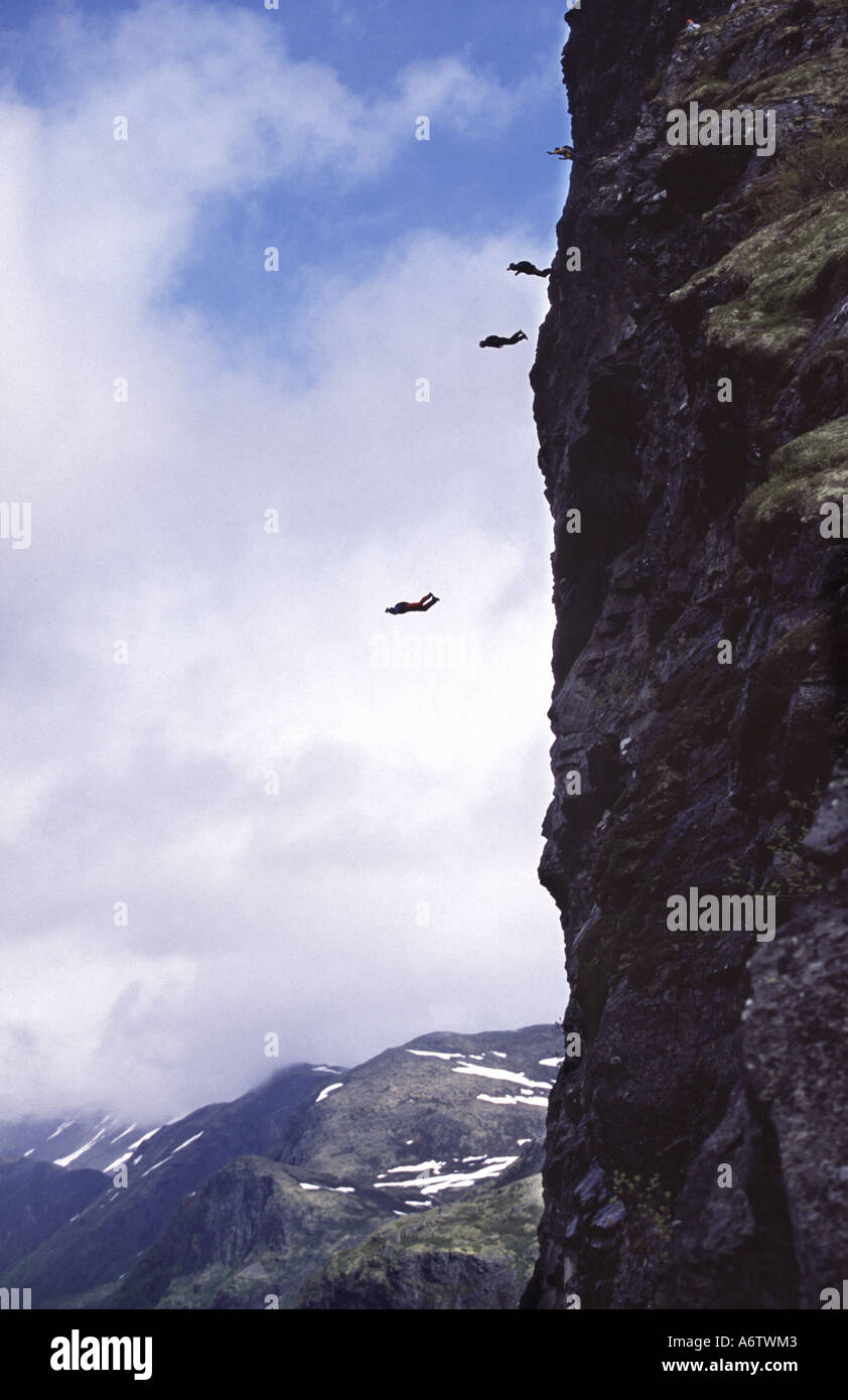 Three base jumpers launching themselves off the cliff face Voss Norway ...