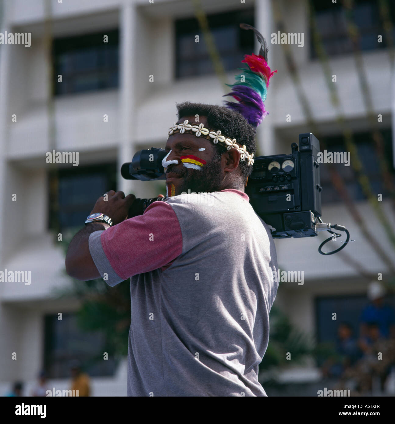 Native of Papua New Guinea with video camera wearing traditional ...