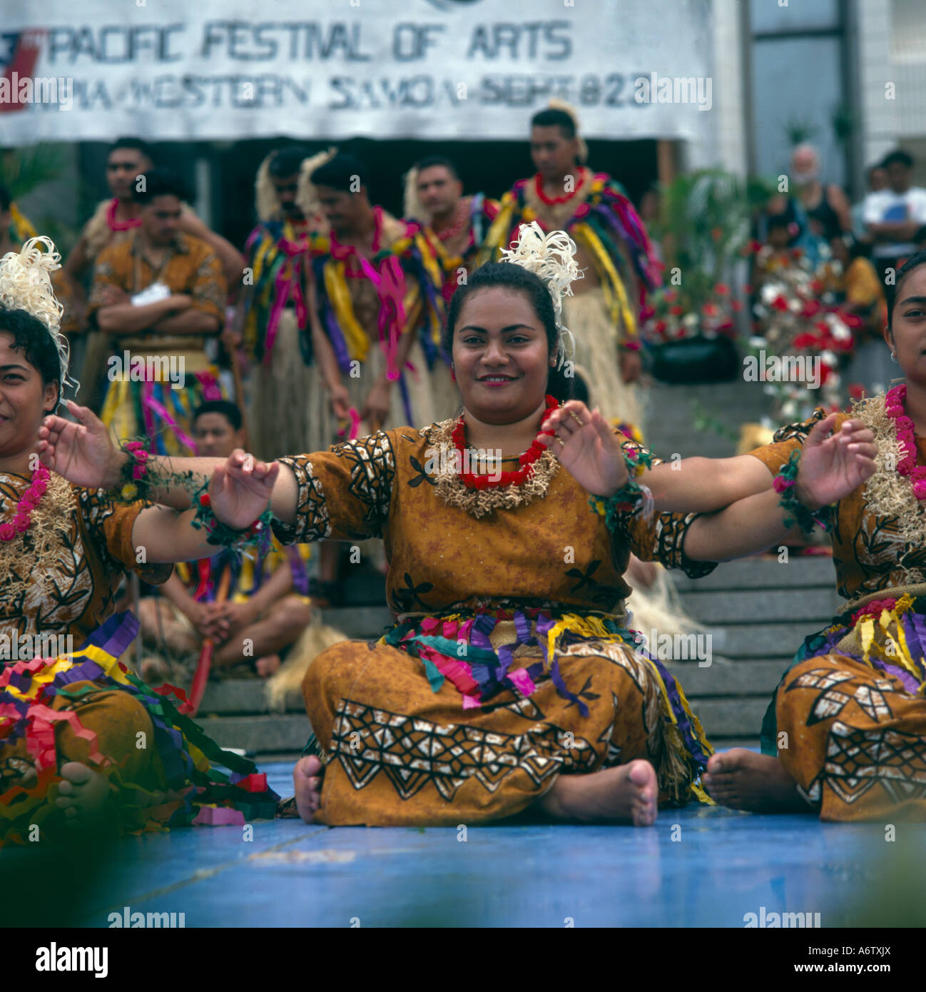 Female Tongan dancer sitting in middle of performing group in ...