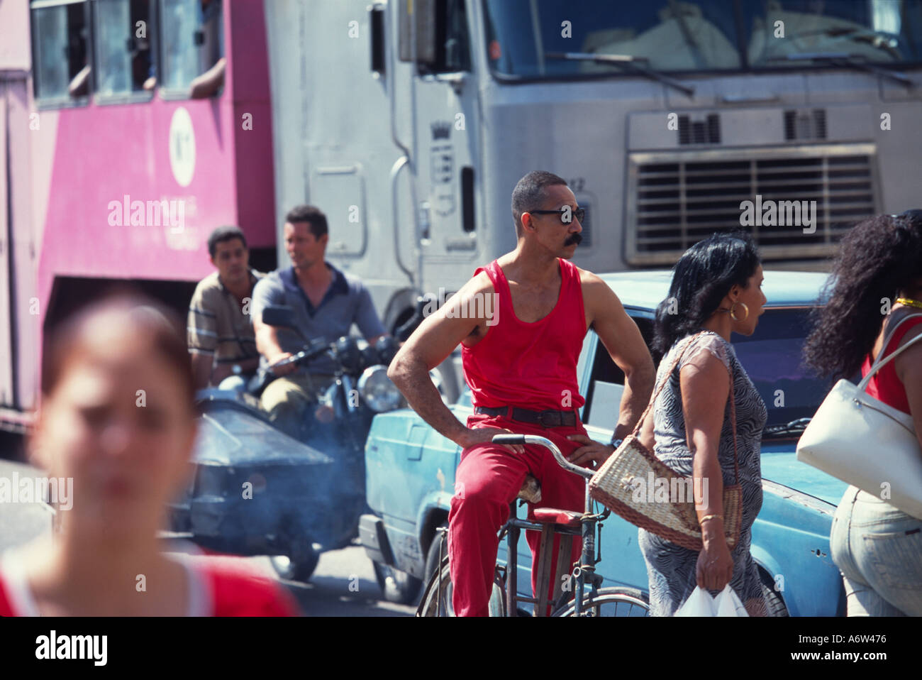 Cuba Havana man sitting on a bicycle amidst heavy traffic with a famous ...