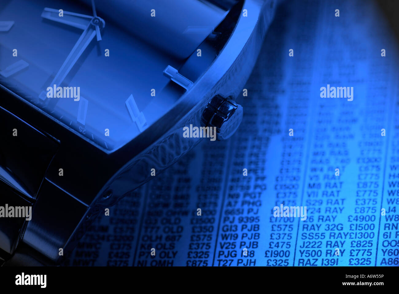 Wrist watch on a newspaper stock listings Stock Photo - Alamy