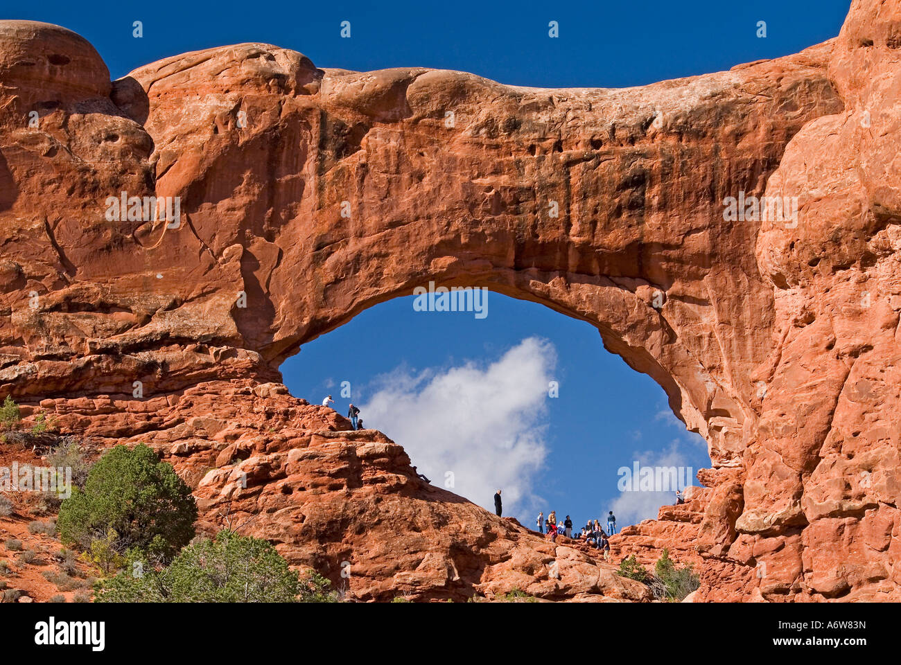 Tourists enjoy natural arch North Window in Arches National Park Utah ...