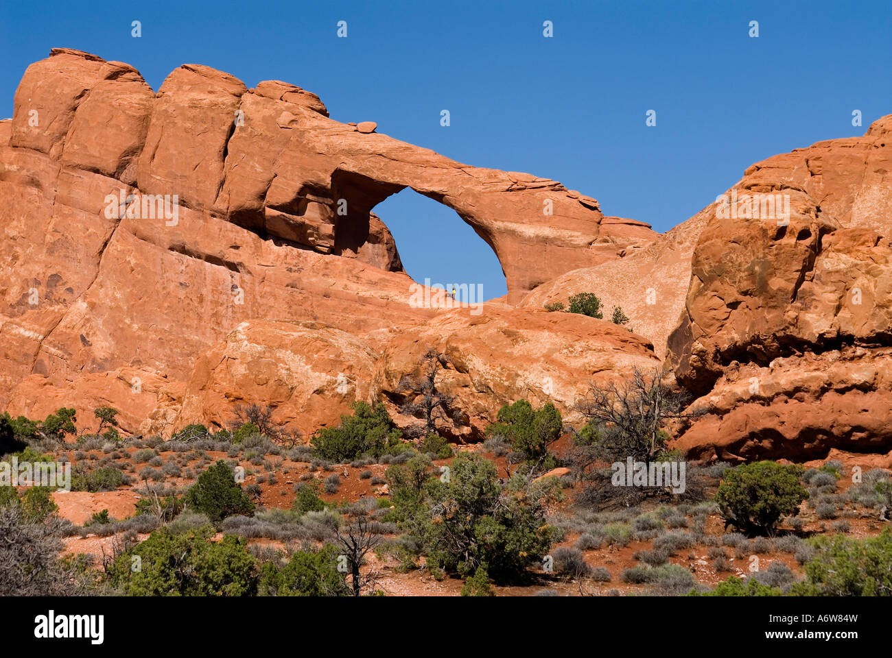 Tourist standing under Skyline Arch in Arches National Park Utah USA ...