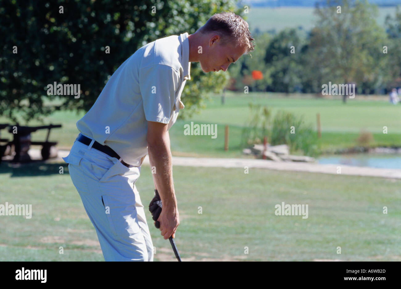 Young man lining up for a golf stroke Stock Photo - Alamy