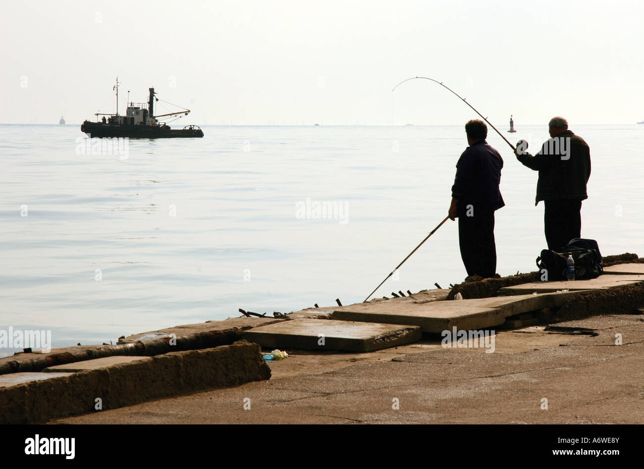 Men fish in the Caspian Sea from a pier in Baku, Azerbaijan Stock Photo ...