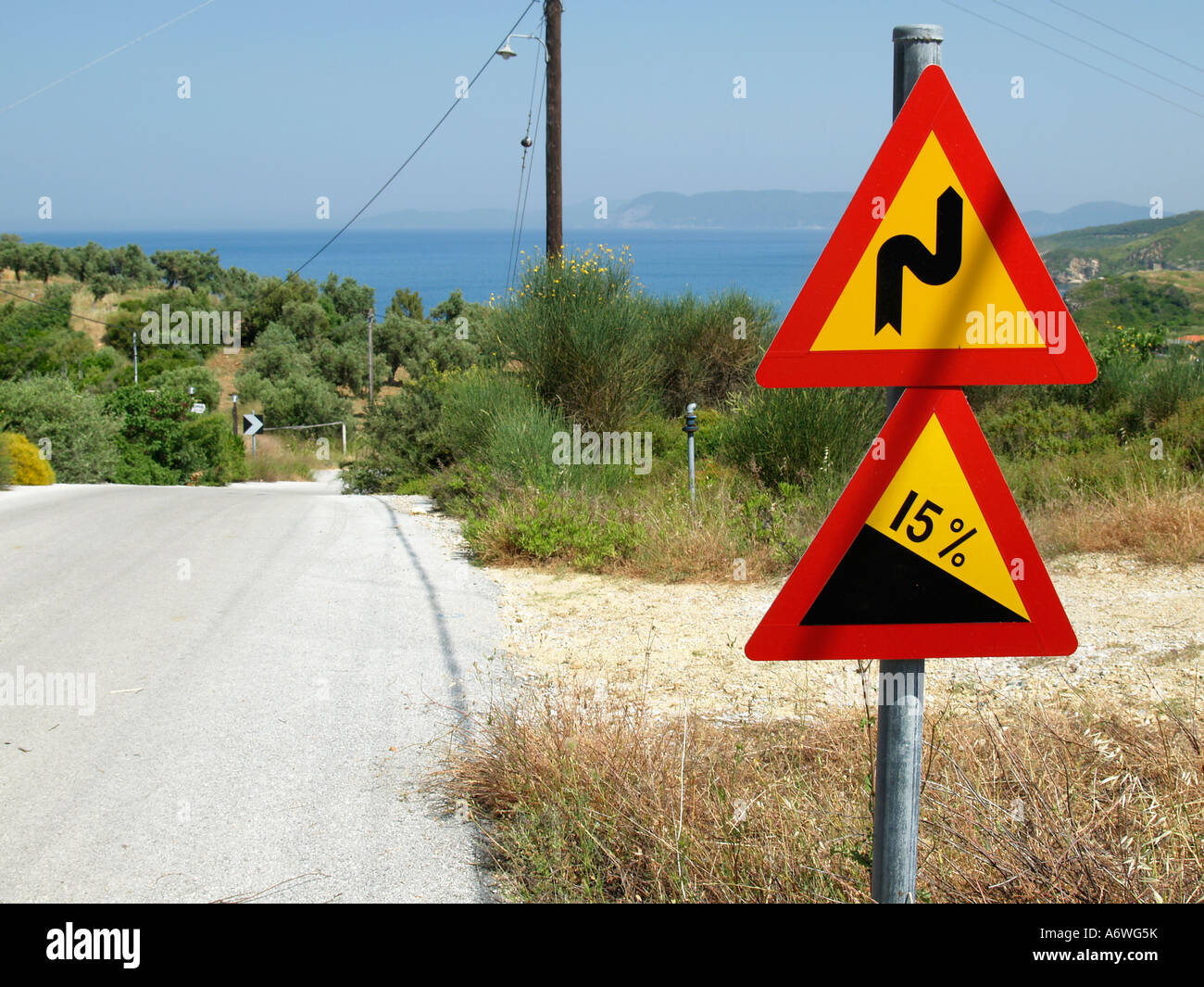 road at Mediterranean Sea with a warning shield traffic sign for ...
