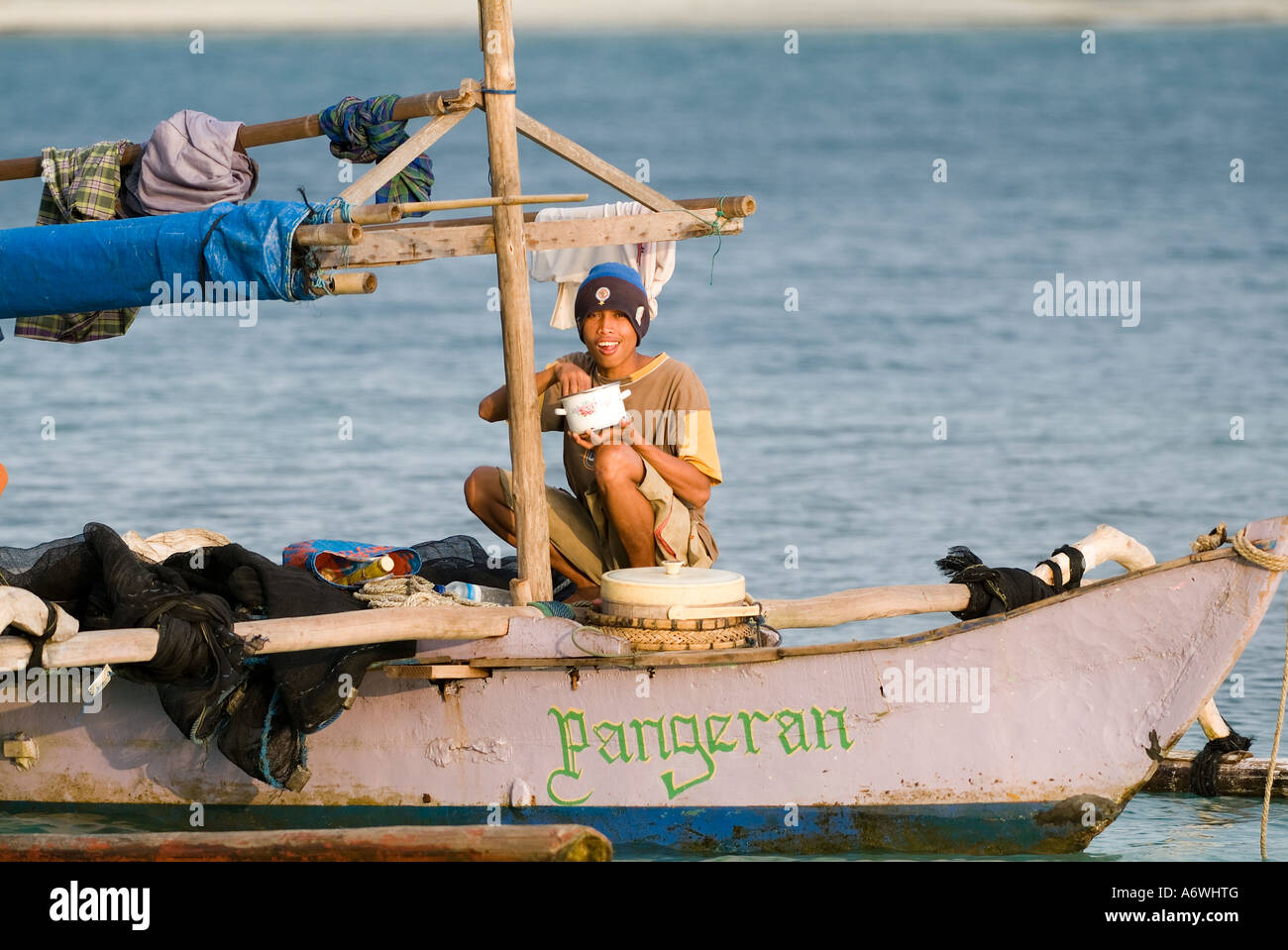 young fisherman eating on boat Stock Photo - Alamy