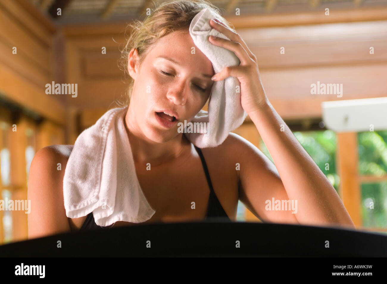young woman wiping sweat after exercising in gym Stock Photo - Alamy