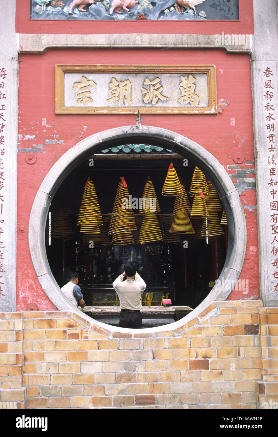 Macau. Round opening frames worshippers burning incense at the A-Ma ...