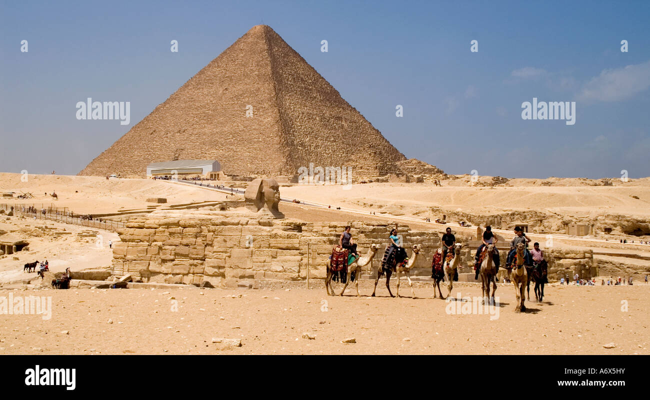 Pyramid of Khufu (Cheops) at Giza, Cairo, Egypt showing tourists on camels in the foreground ...