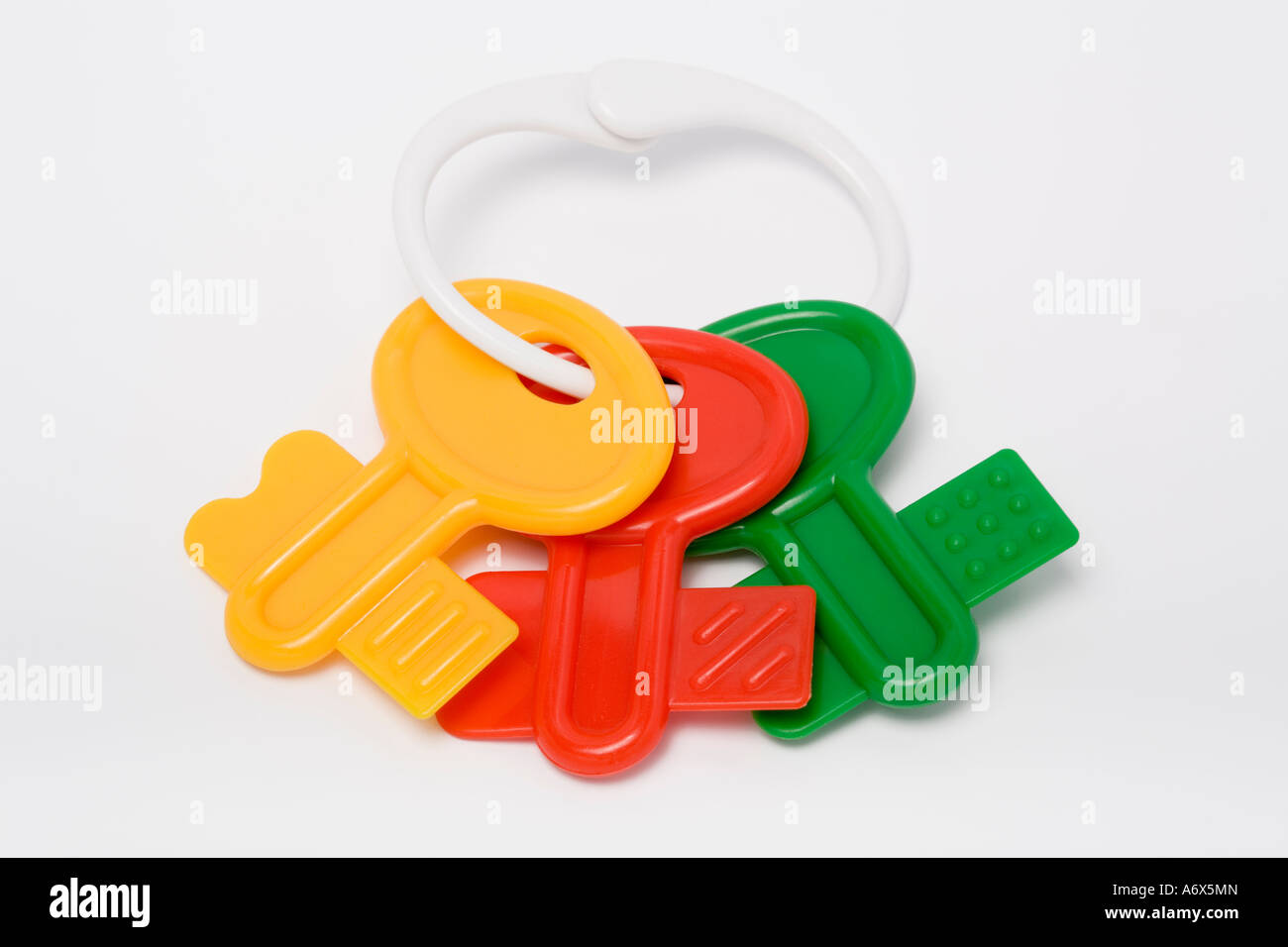 Three (3) plastic baby key toys, on white background. Yellow, Red and ...