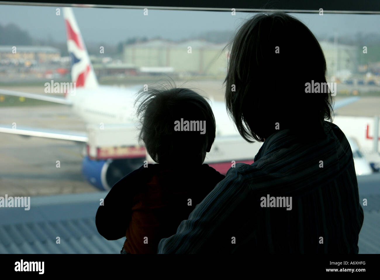 mother and baby watching aircraft from airport terminal Stock Photo - Alamy