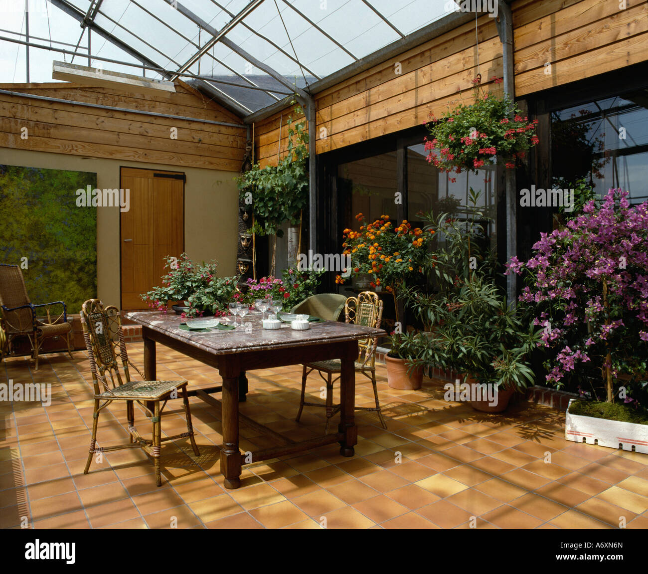 Dining table and chairs on tiled floor in conservatory extension Stock ...