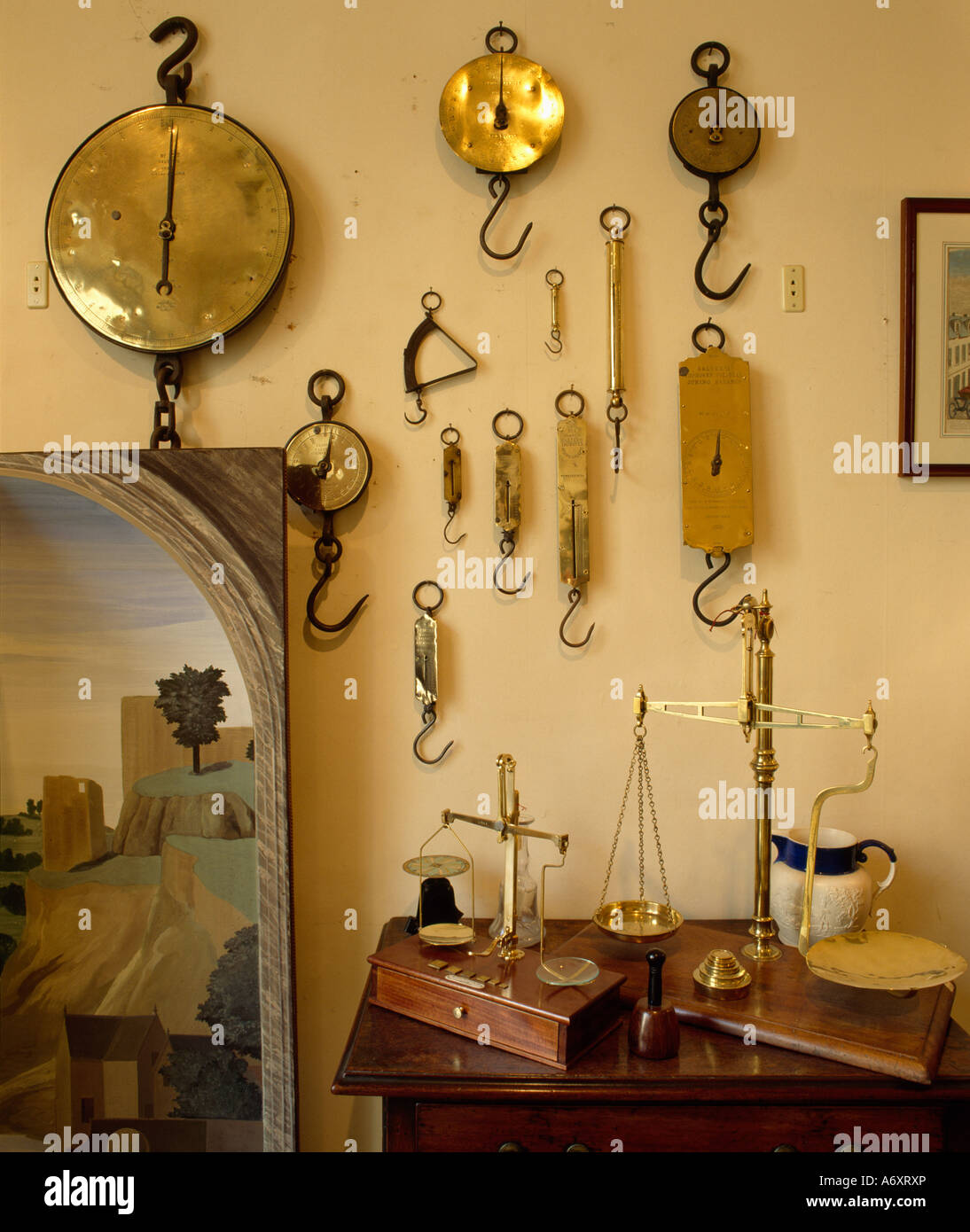 Collection of antique brass scales on wall above antique scales on ...