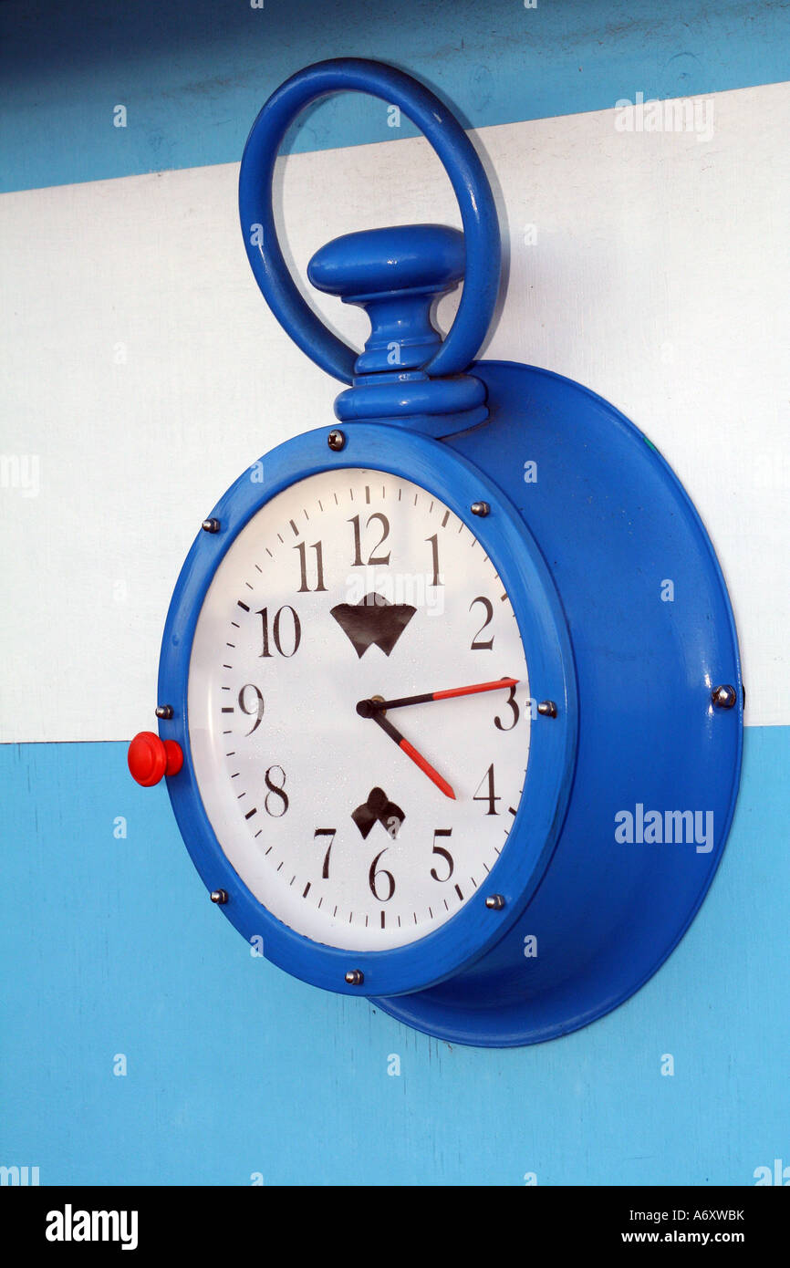 Blue clock attached to an external wall Stock Photo - Alamy