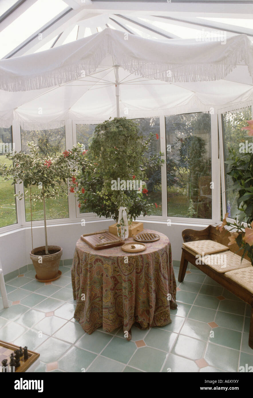 Large white garden parasol above small table with patterned cloth in ...